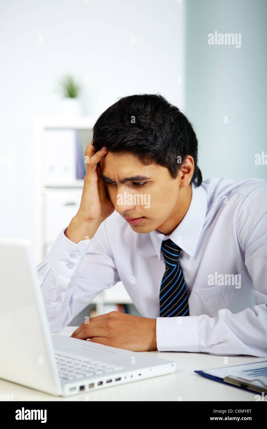 Portrait of a businessman looking at laptop screen in office Stock ...