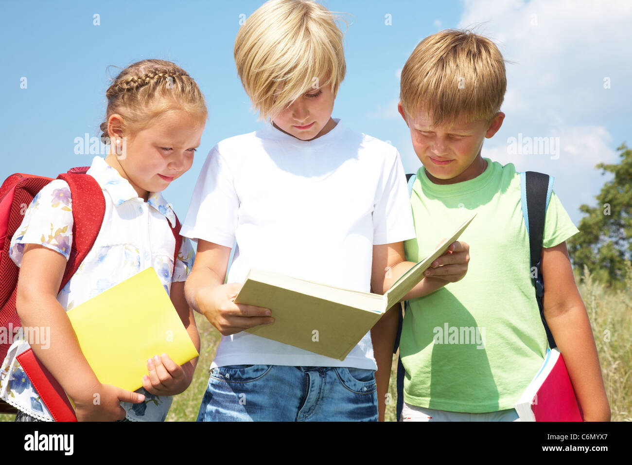 primary schoolchildren enjoying reading the same book, in the late ...