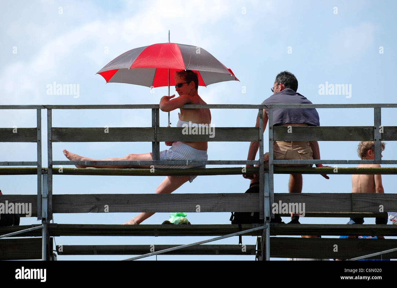 Drag racing fan using umbrella for shade from the hot sunny weekend ...
