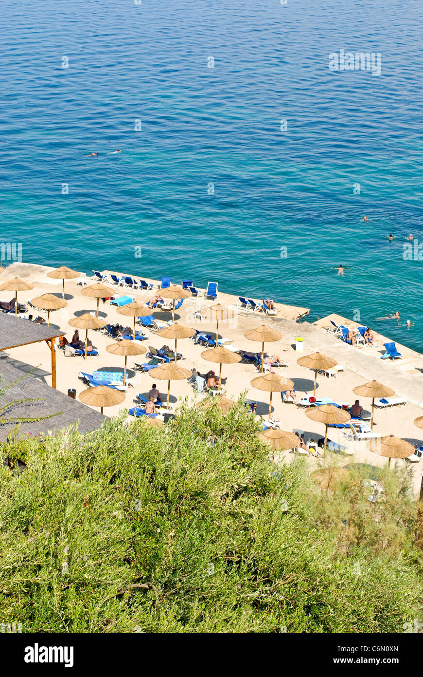 View down on a Greek Mediterranean beach with parasols and sun loungers ...