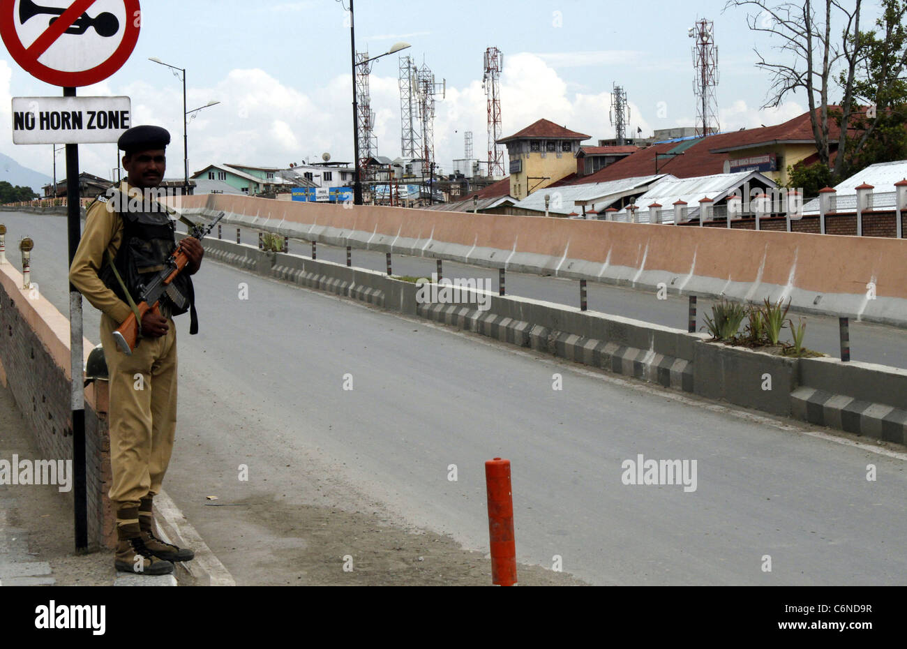 Indian policemen stand guard at an entry point to the city during a ...