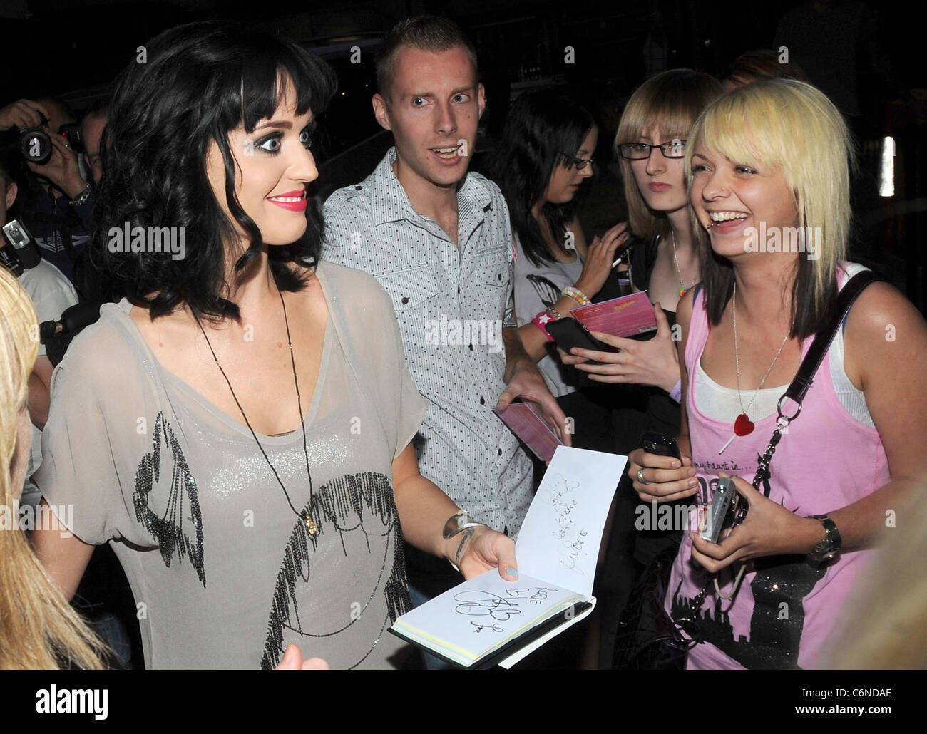 Katy Perry autographs t-shirts and poses for photographs as she is ...