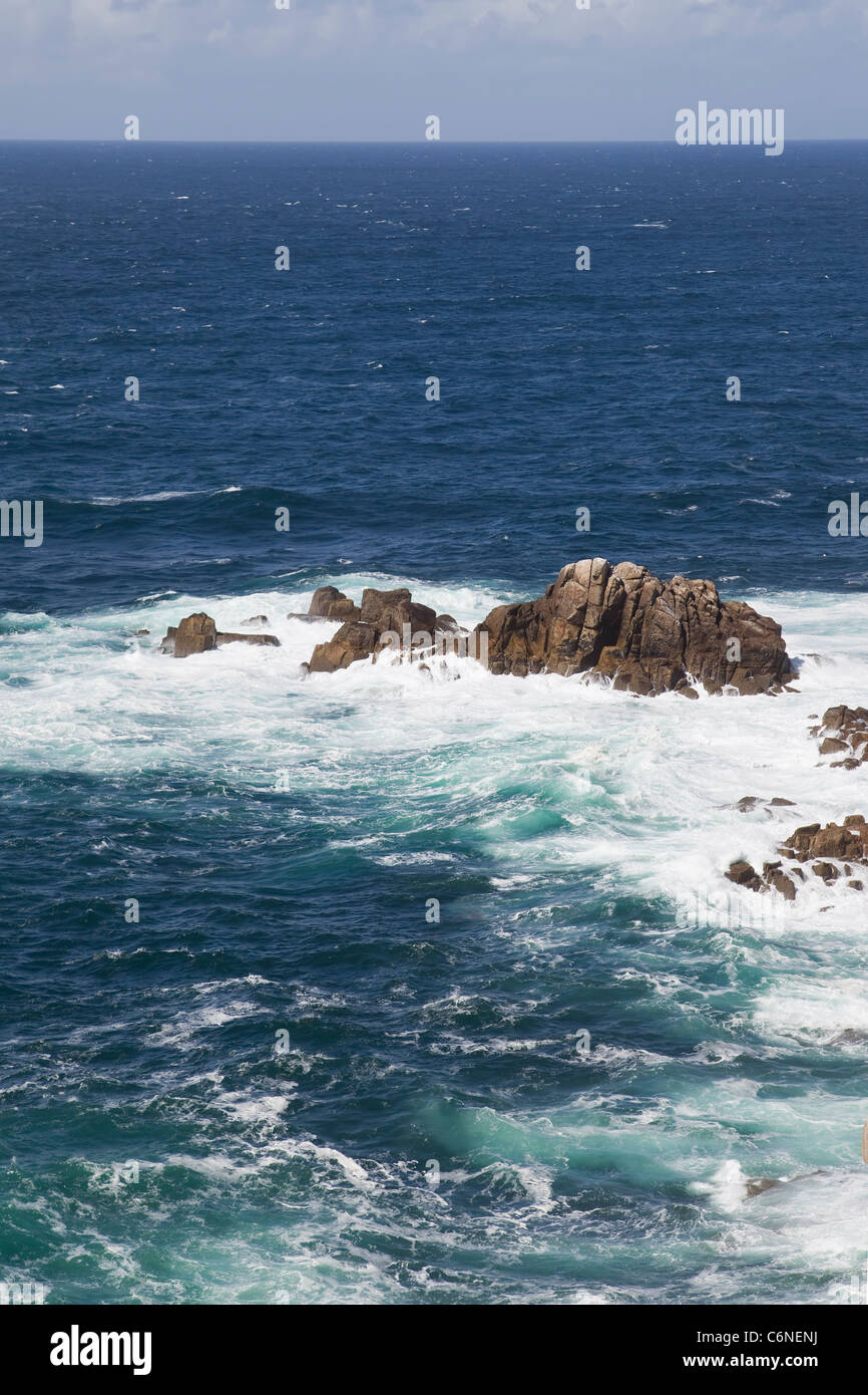 Lands End Cornwall with waves and rough sea breaking over the rocks ...