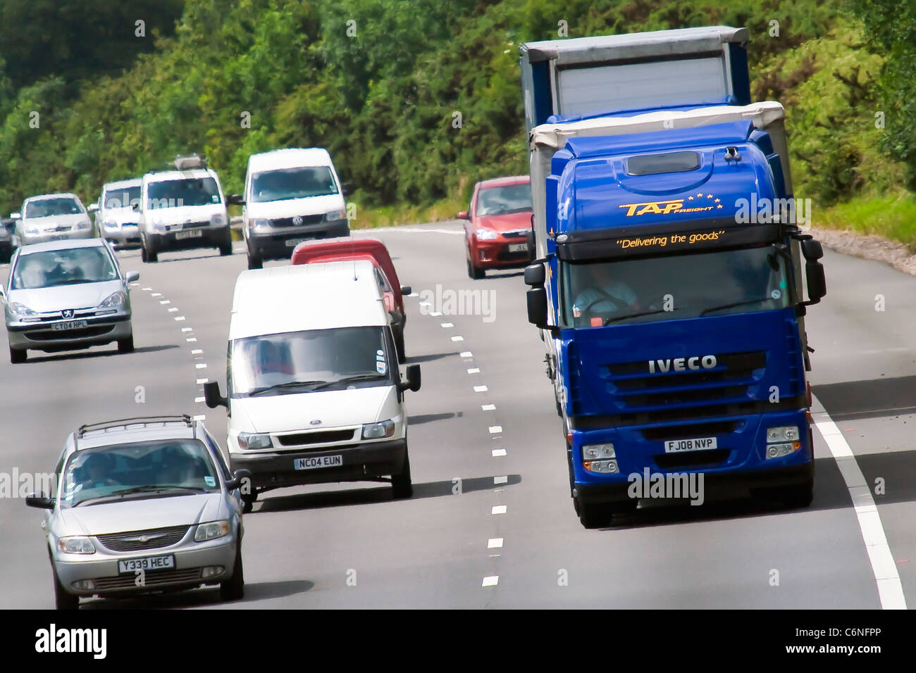 A busy road scene with heavy traffic, featuring a mix of trucks ...