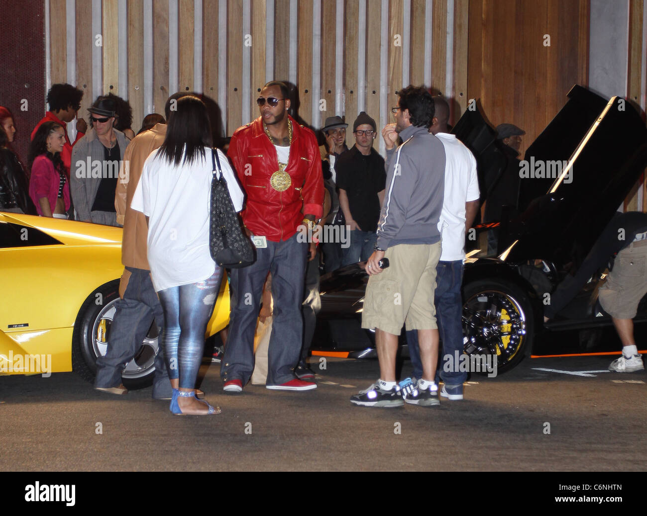 Flo Rida(C) stands next to some luxurious cars on the set of his new ...