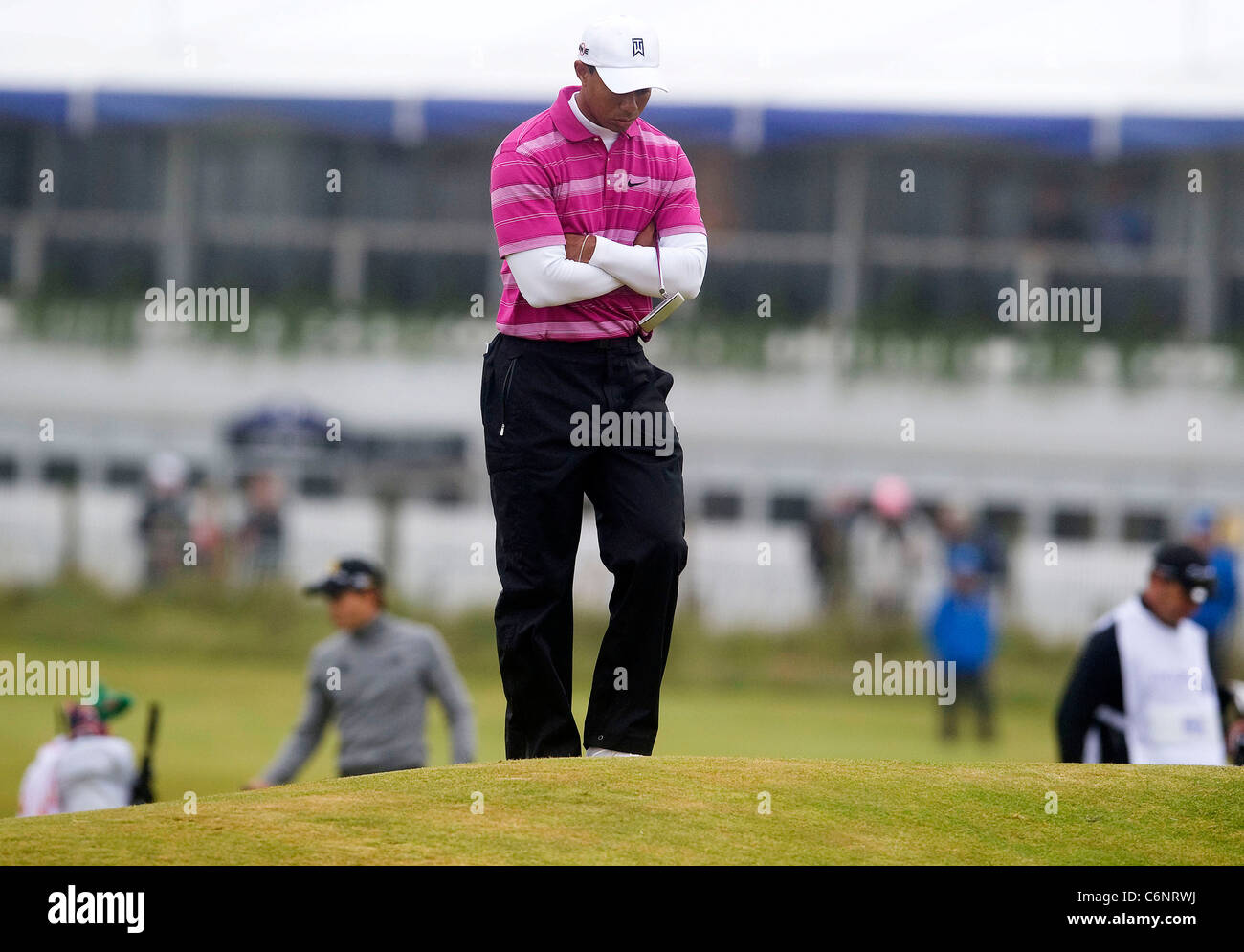 Tiger Woods cuts a disconsolate figure as he heads to the third green ...
