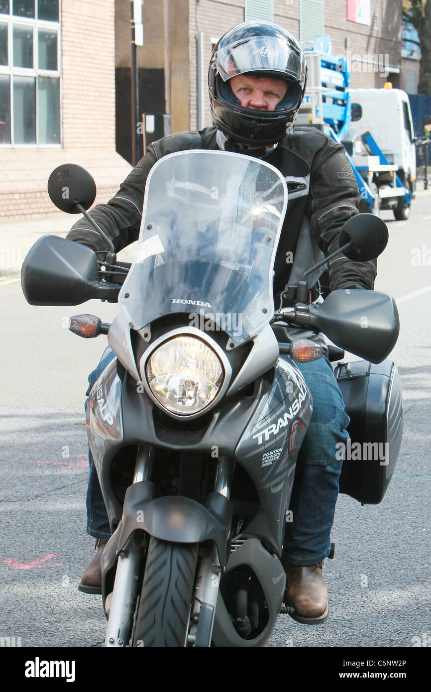 Adrian Chiles Arrives by motorcycle for a photo shoot at a studio in ...