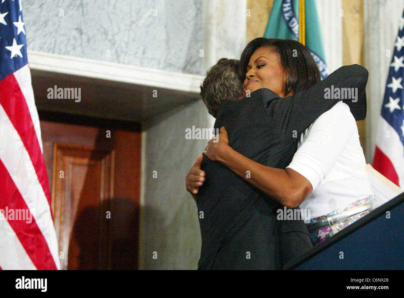 Secretary of Treasury Timothy Geithner and Michelle Obama share a hug ...