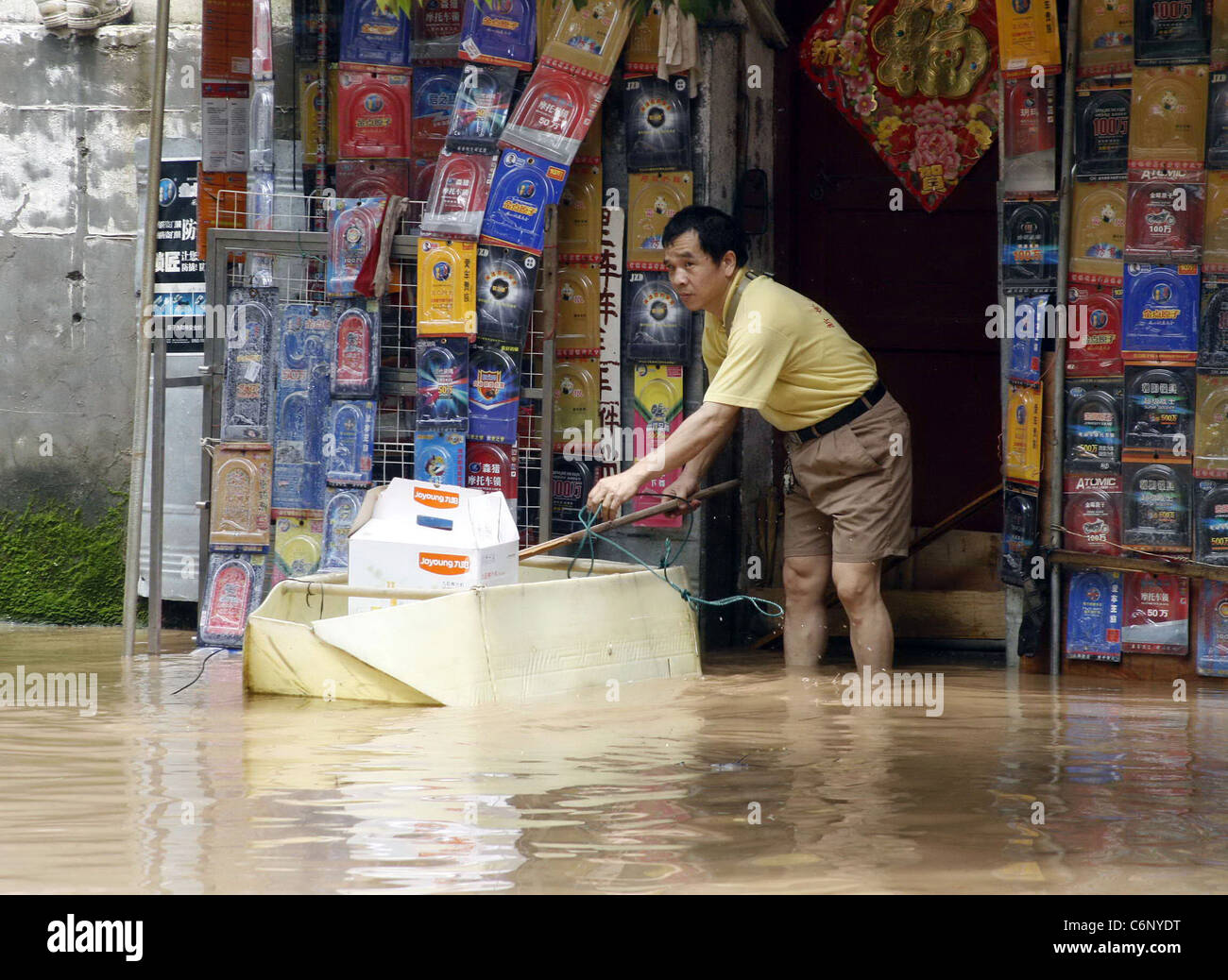 A man prepares to row a self-made raft in the floods in downtown Guilin ...