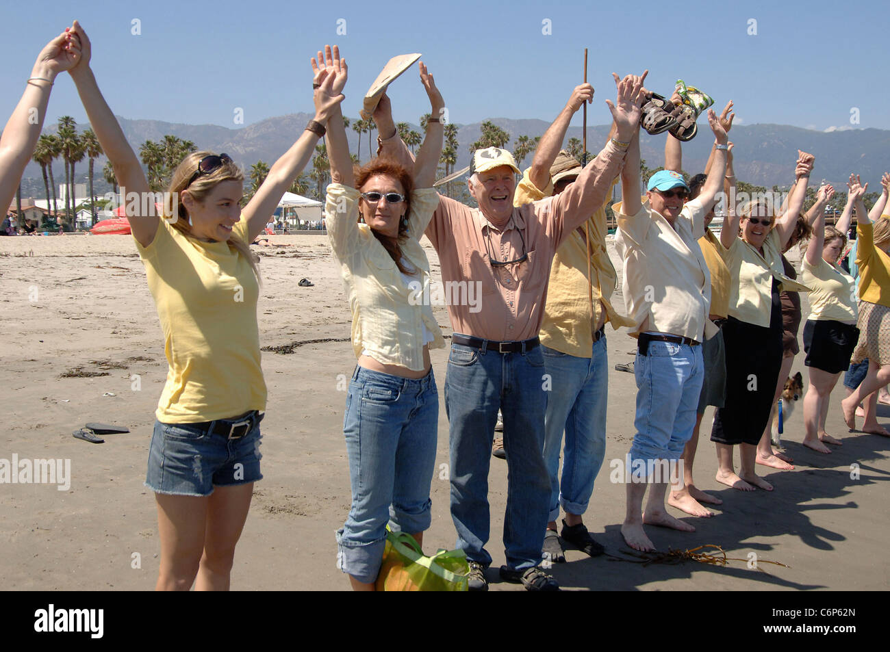 People stand together during a Hands Across The Sand event at the beach ...