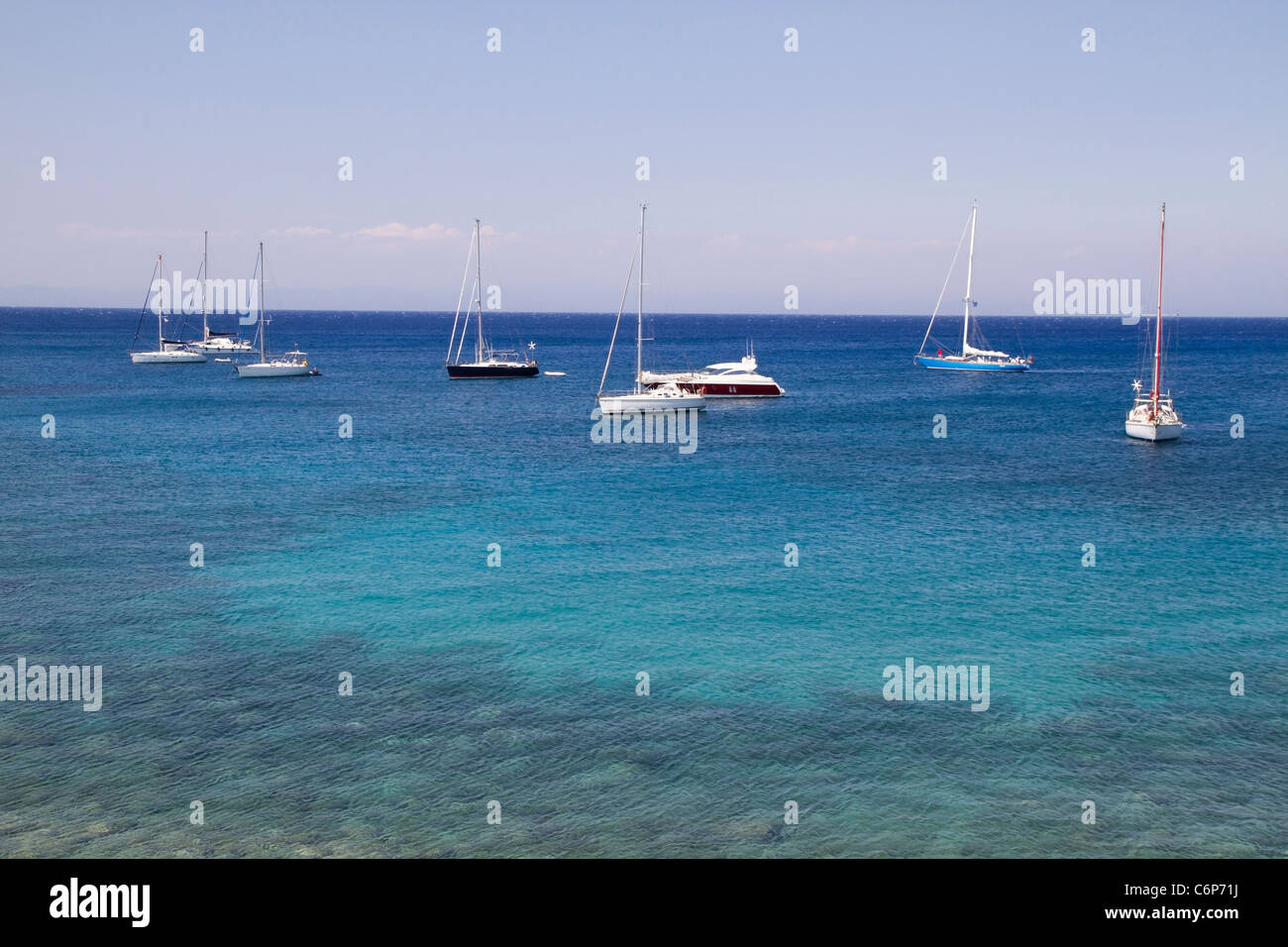Many sailing boats on clam ocean and blue sky Stock Photo - Alamy