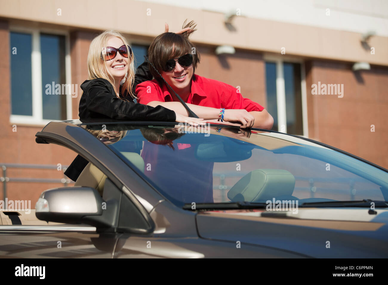 Happy young couple in the convertible car Stock Photo - Alamy