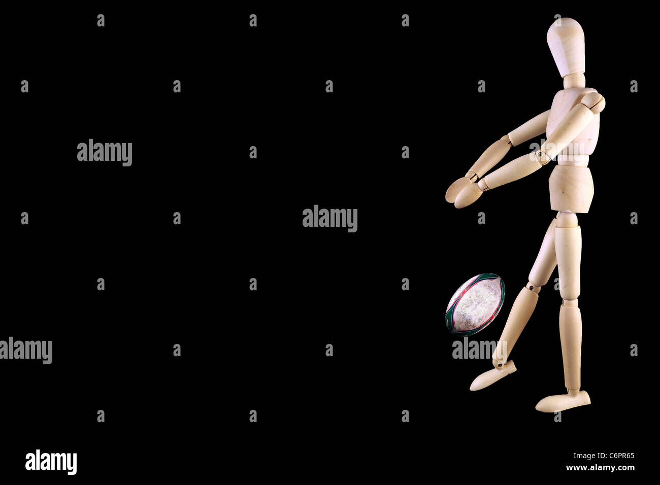 Wooden Mannequin shown with rugby ball isolated on black Stock Photo ...