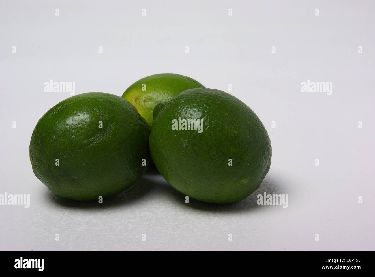 Three limes sit on a plain white background Stock Photo - Alamy