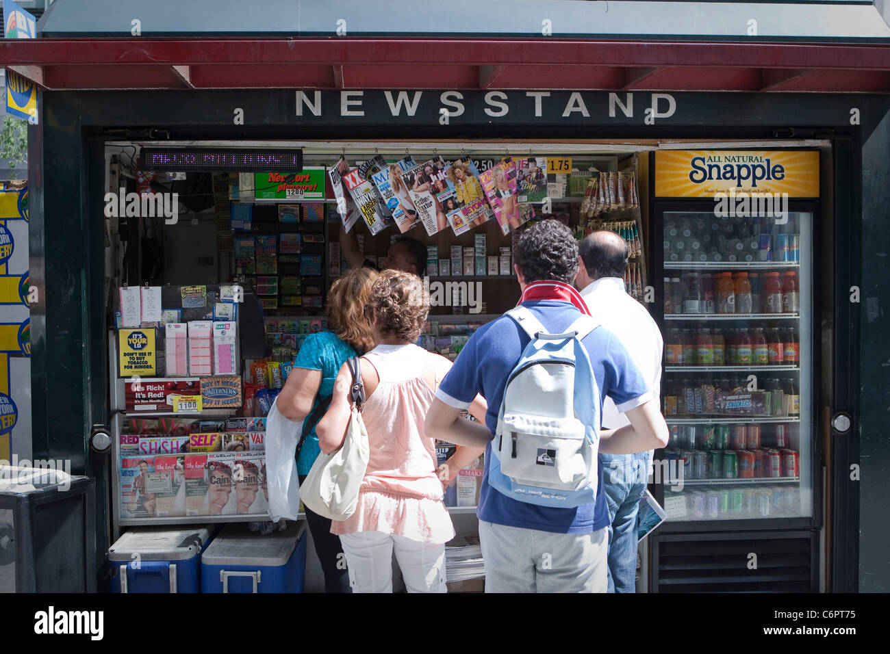 Clients wait in line at a Newsstand shop in the New York City borough ...