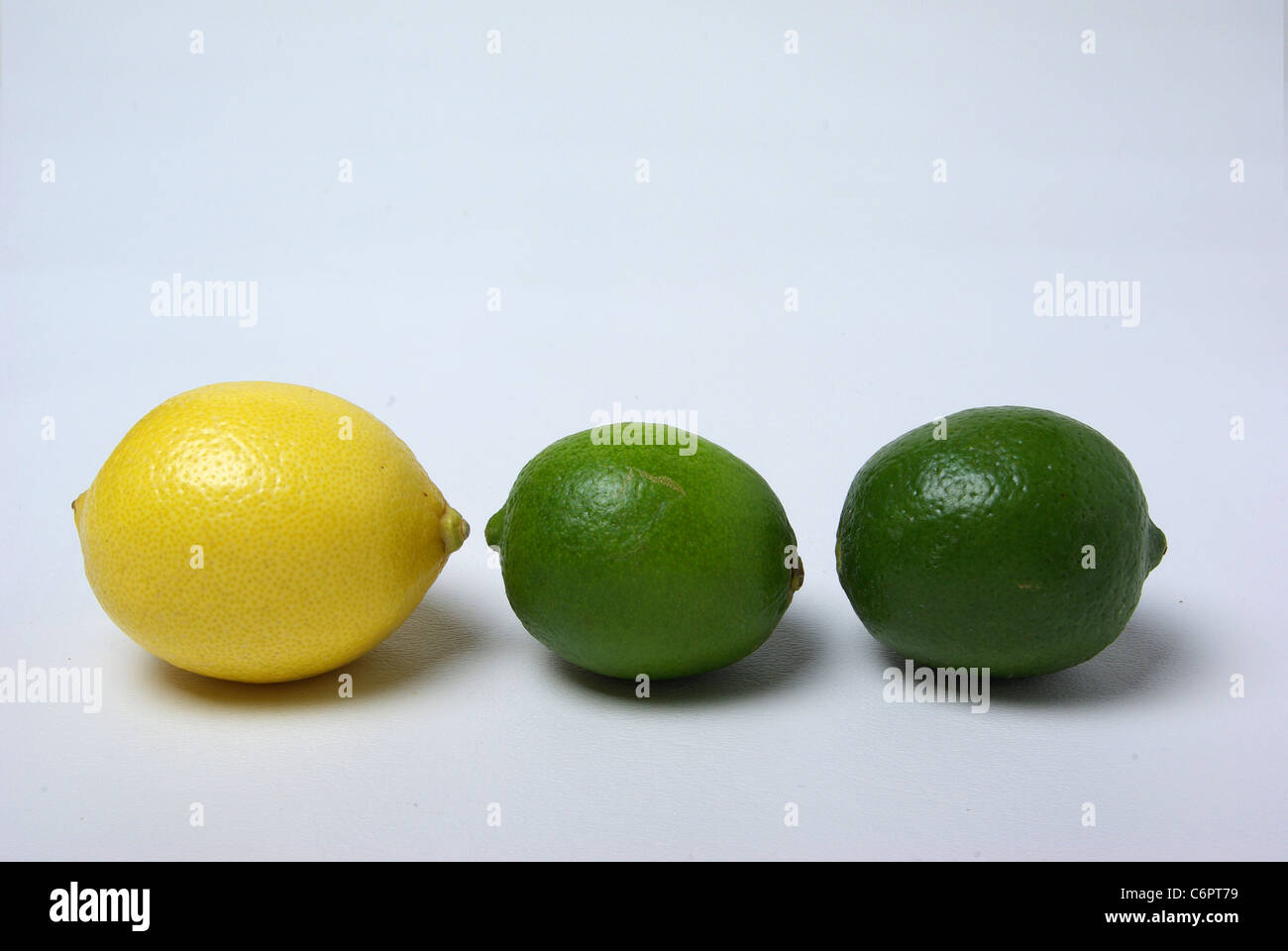Two limes and a lemon sit on a white background Stock Photo - Alamy