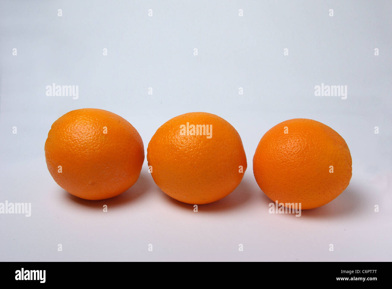 Three oranges are siting on a white background Stock Photo - Alamy