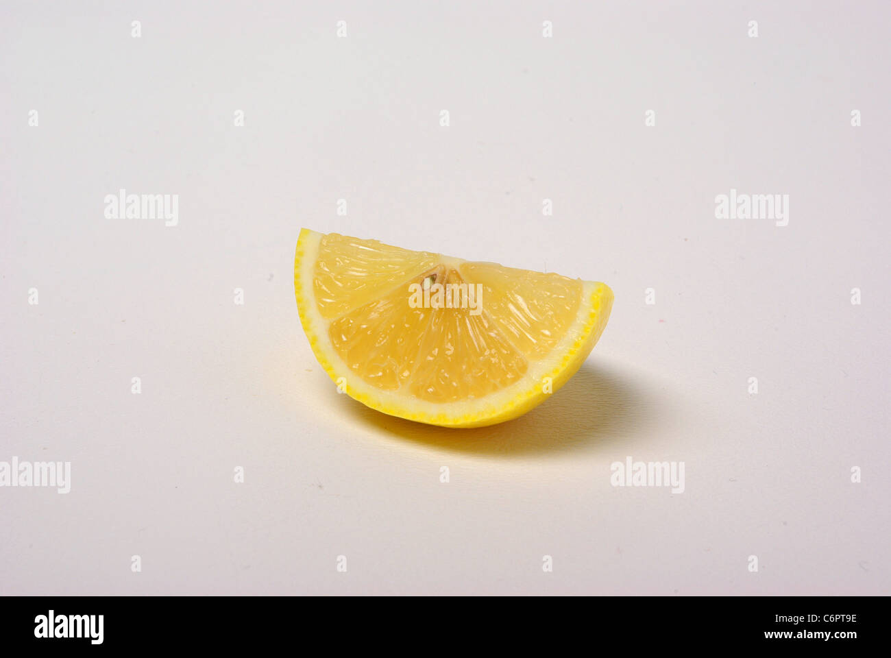 A quarter slice of lemon sits on a white background Stock Photo - Alamy