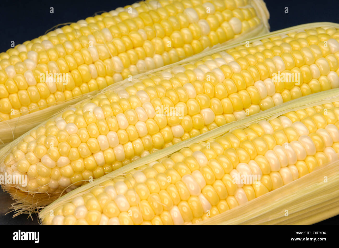 Three ears of corn closeup artistic food background Stock Photo - Alamy