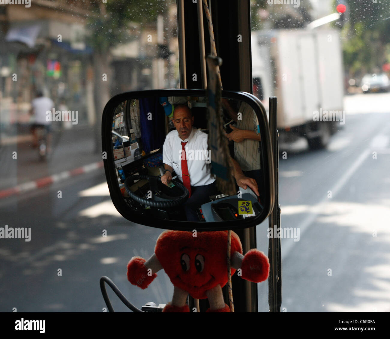 An Israeli bus driver in Tel Aviv is giving a passenger his ticket ...