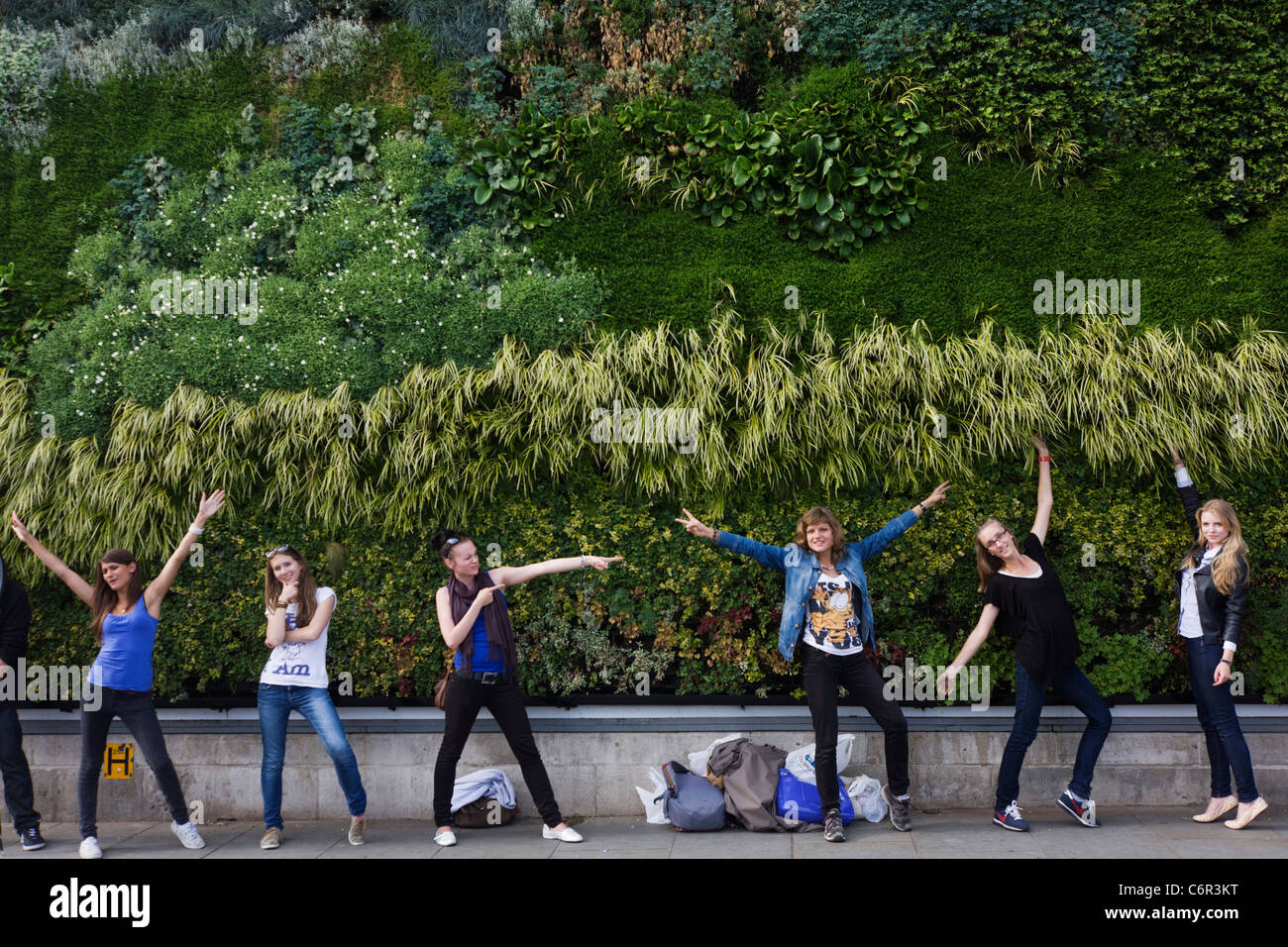 Women pose in front of the GE Ecomagination living wall art project at ...