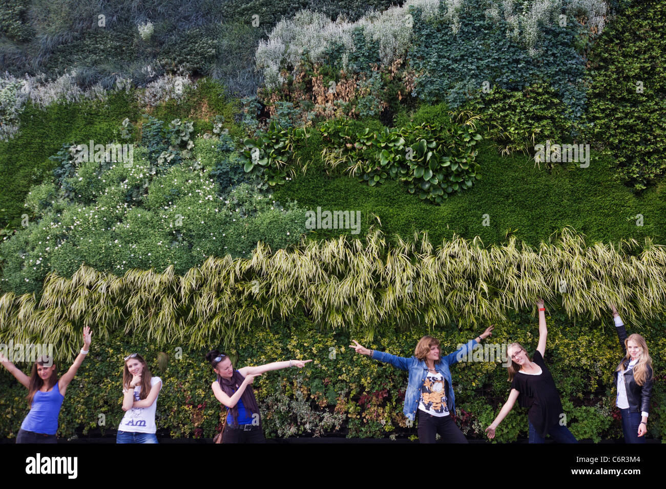 Women pose in front of the GE Ecomagination living wall art project at ...
