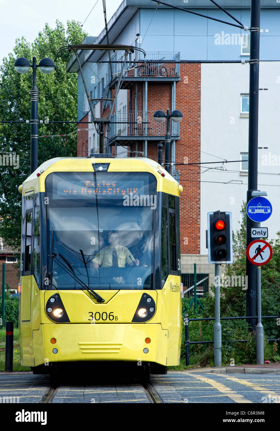 New yellow Metrolink tram crossing a road Stock Photo - Alamy