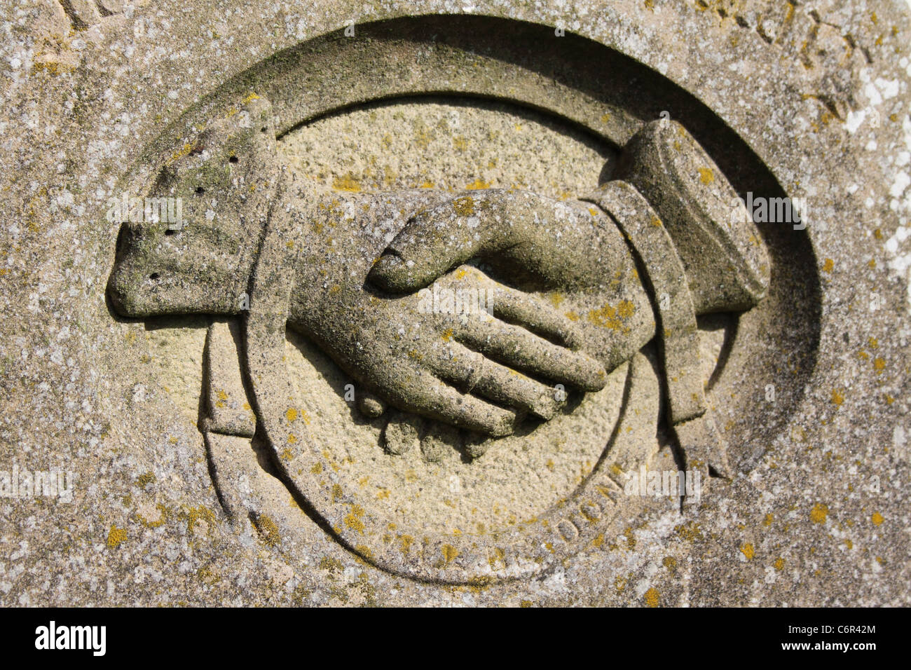 Stone engraving on a headstone of a handshake with the caption, 'Thy ...