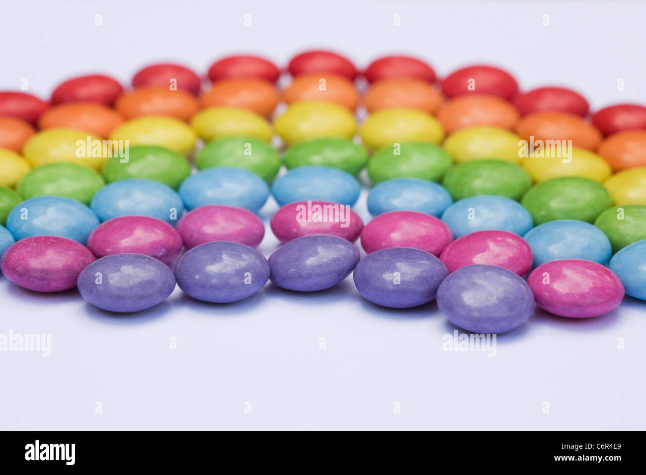 Rainbow smartie pattern on a white background Stock Photo - Alamy
