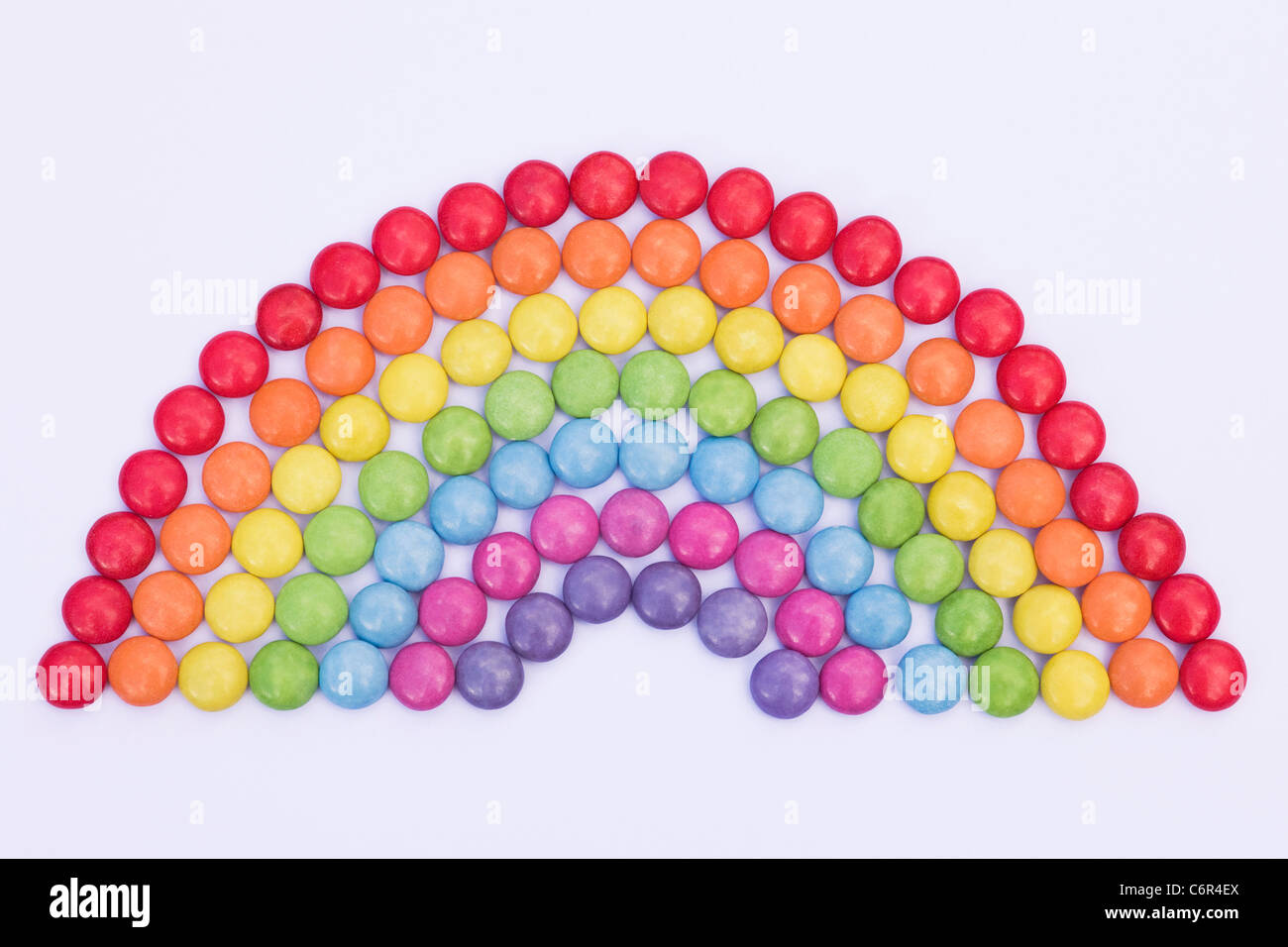 Rainbow smartie pattern on a white background Stock Photo - Alamy