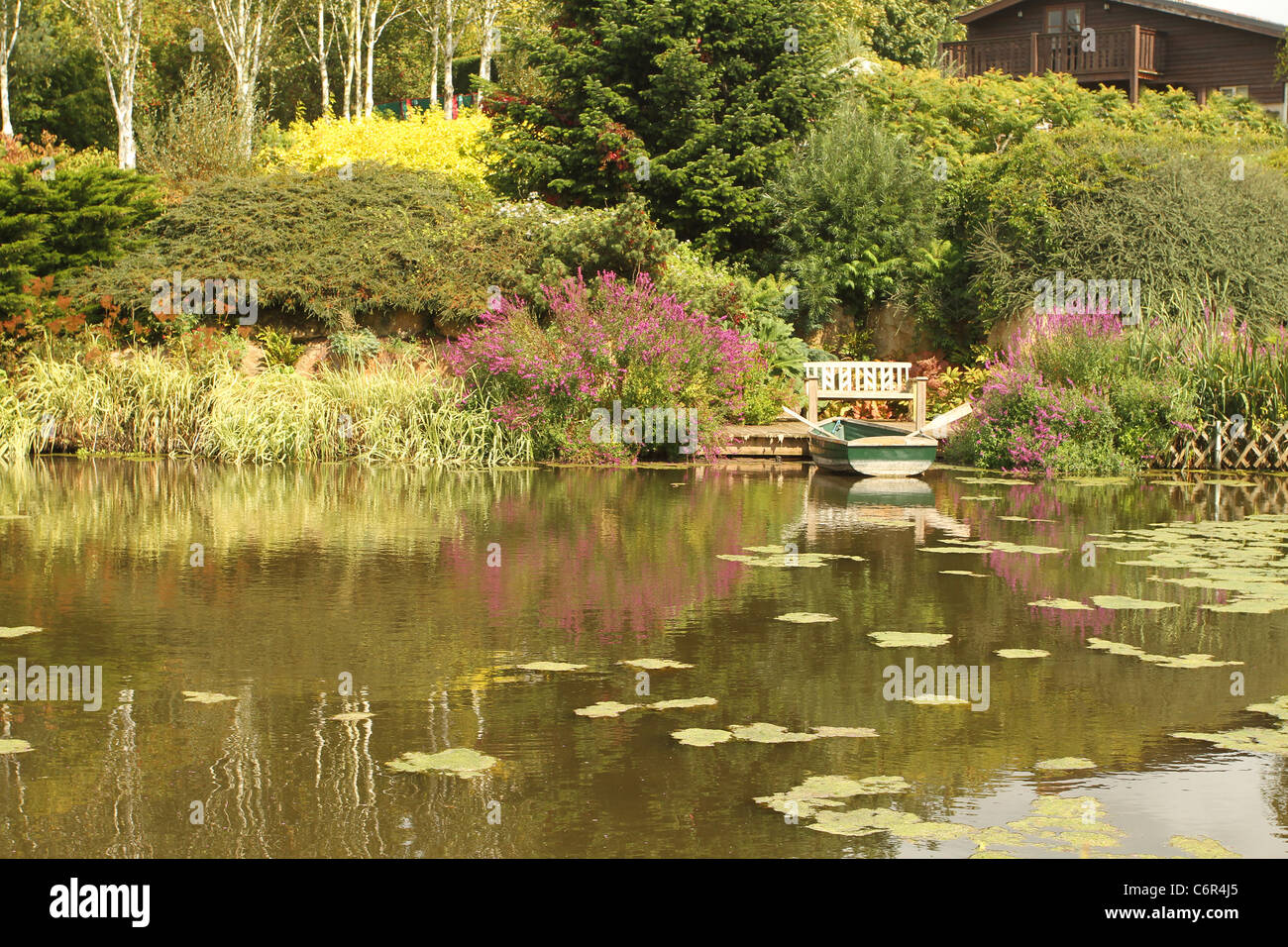 Small lake in an English country garden, with boat Stock Photo - Alamy
