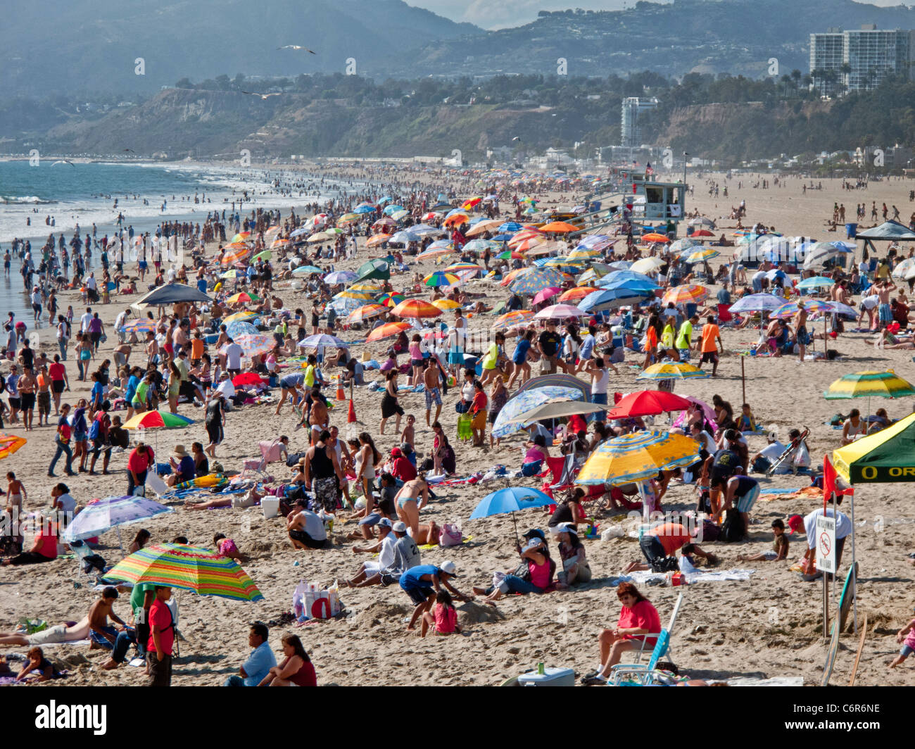A weekend crowd enjoys Pacific Ocean summer weather on the beach in ...
