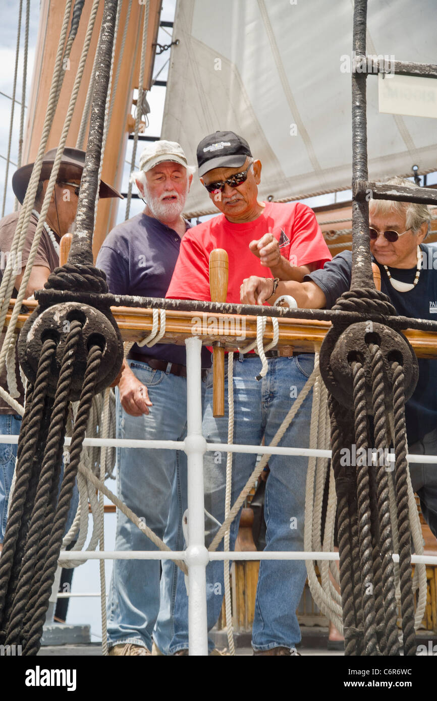 An experienced sailor conducts a knot-tying class at the rail of the ...