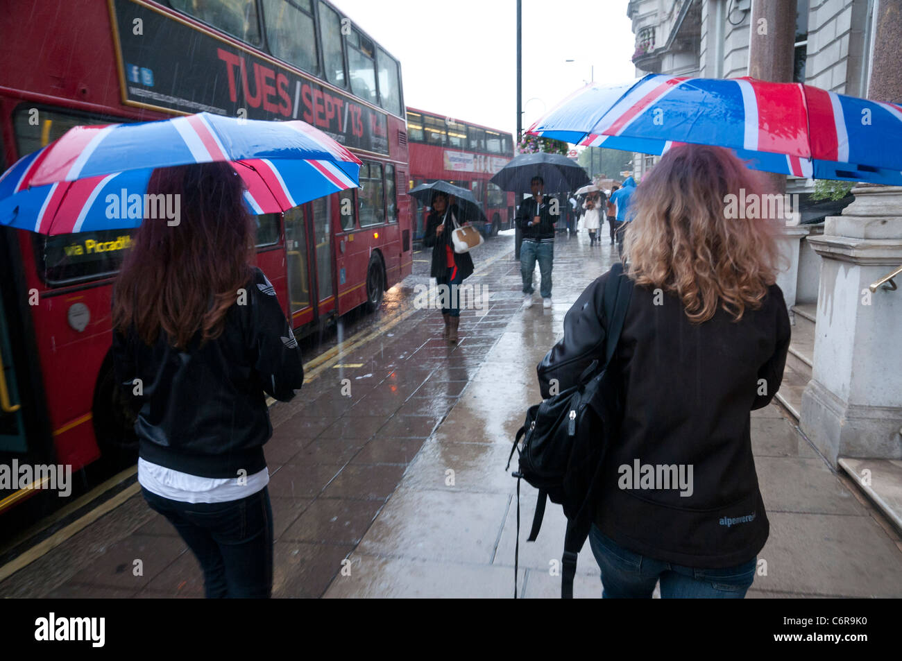 woman with union jack flag in heavy rain. Piccadilly. london. England ...