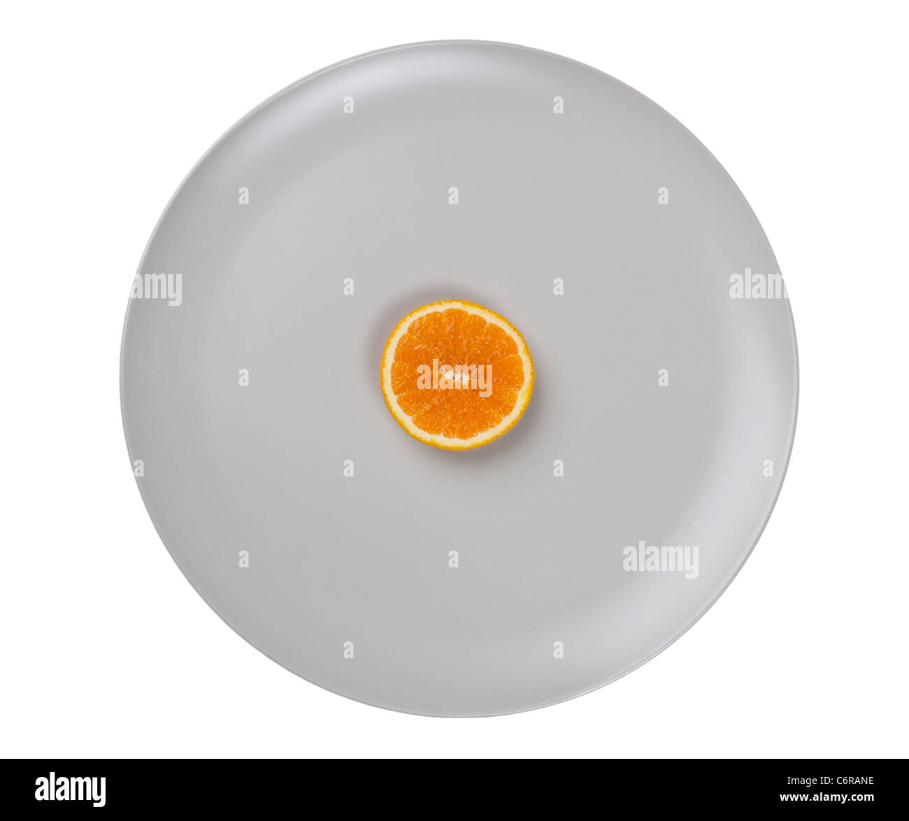 Slice of orange in the center of a big plate isolated on white ...