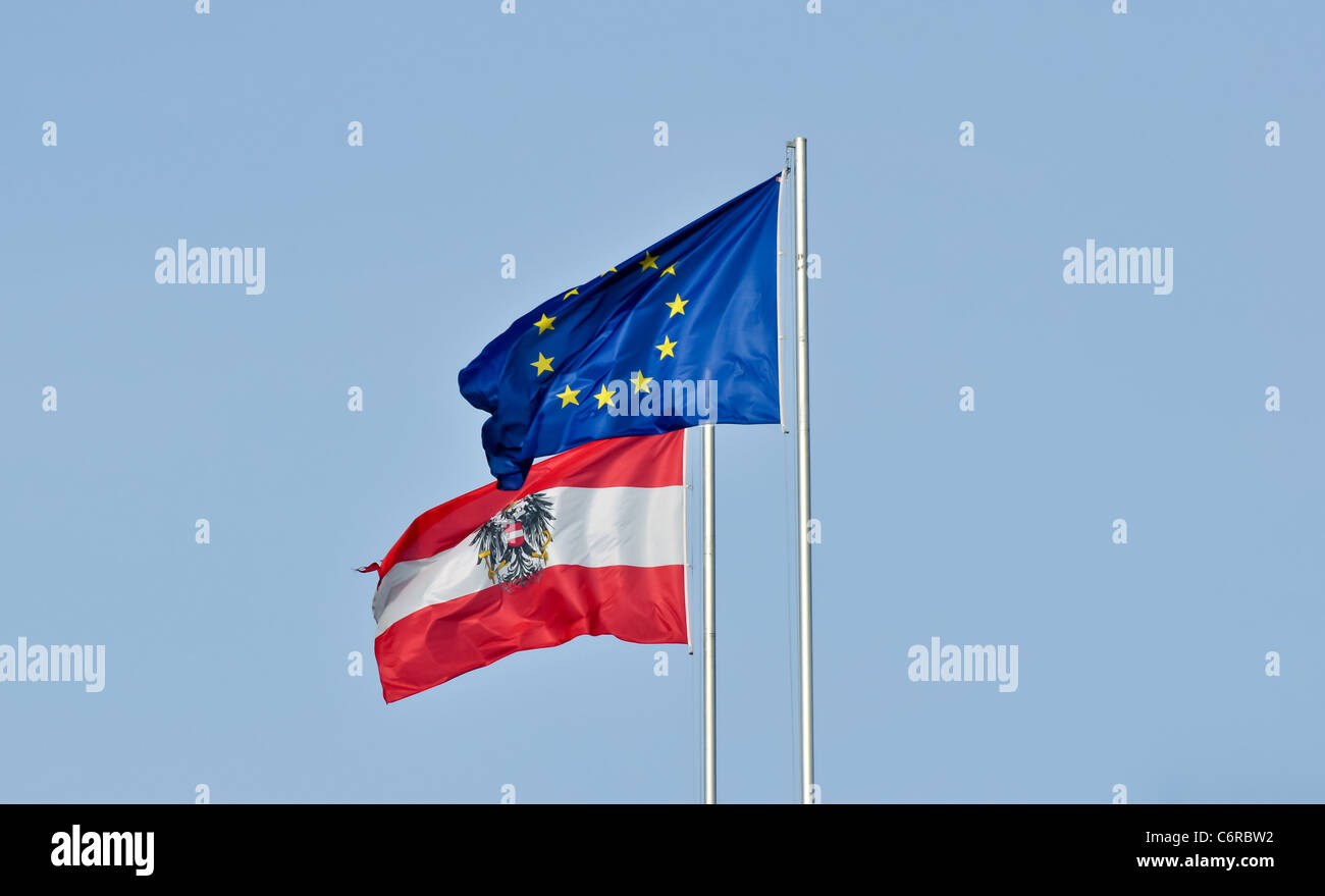 flags of austria and the european union flying together against a blue ...