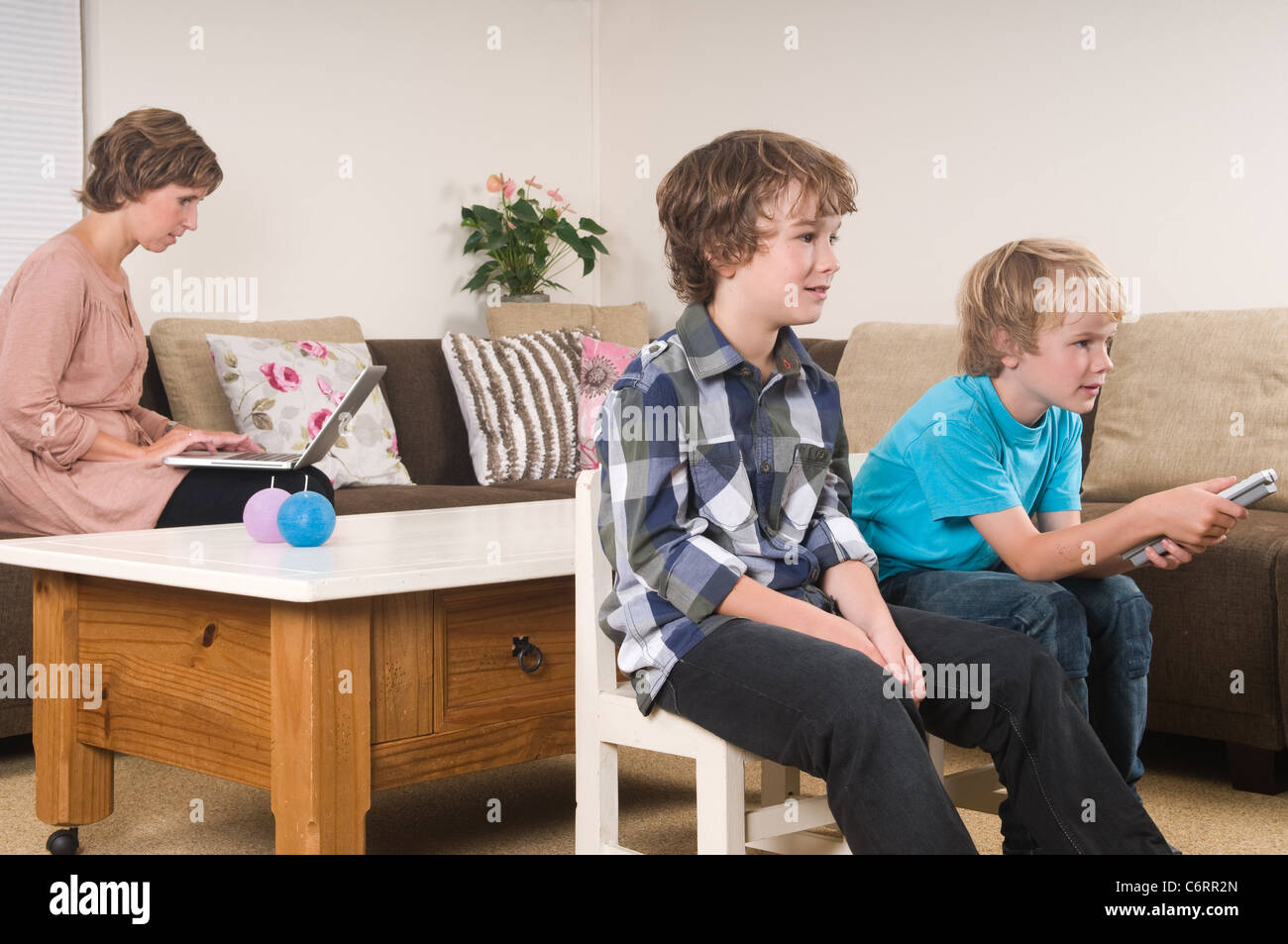 Children are watching tv while mother is working in the background ...