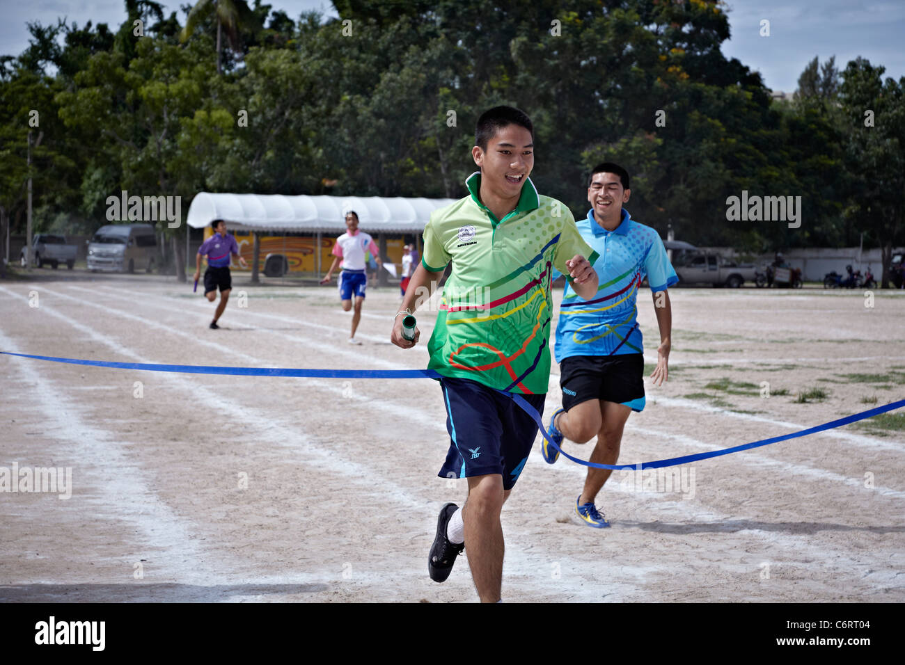 Winner crossing the finishing line at an Asian school sports day event ...