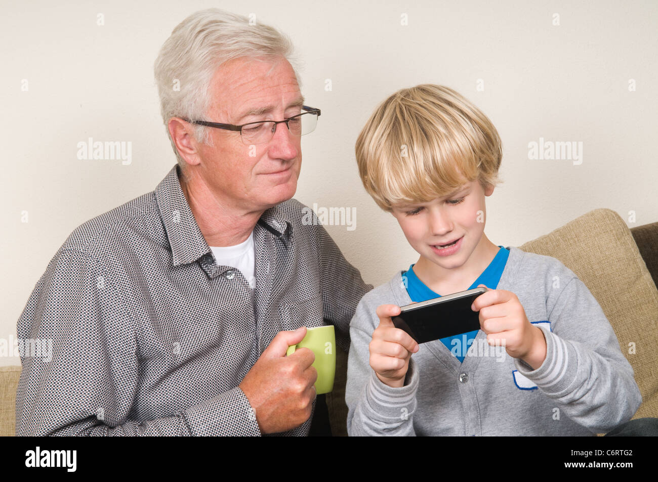 This kid learns his grandpa to use a smartphone Stock Photo - Alamy