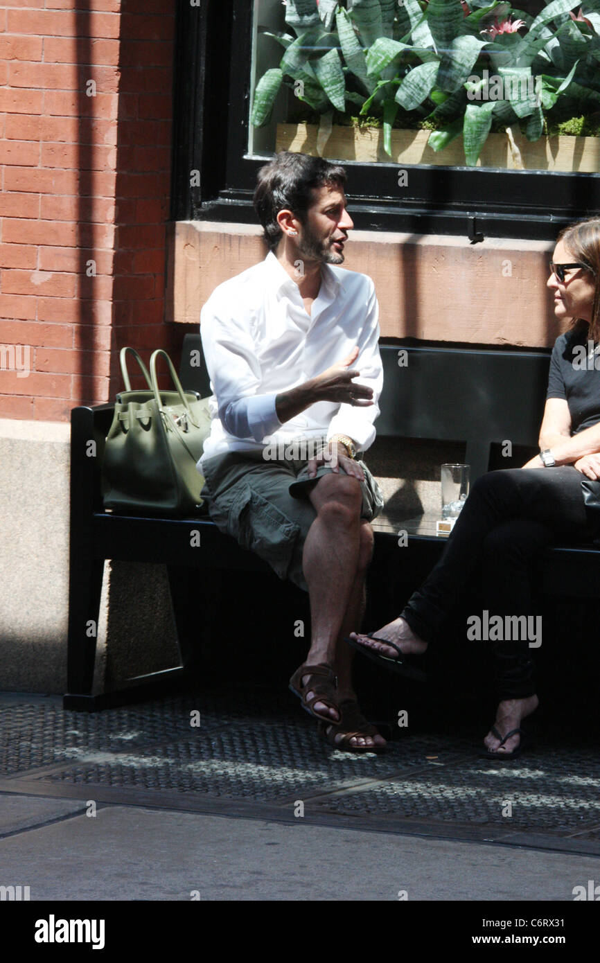 Fashion designer Marc Jacobs sitting on a bench talking to a female ...