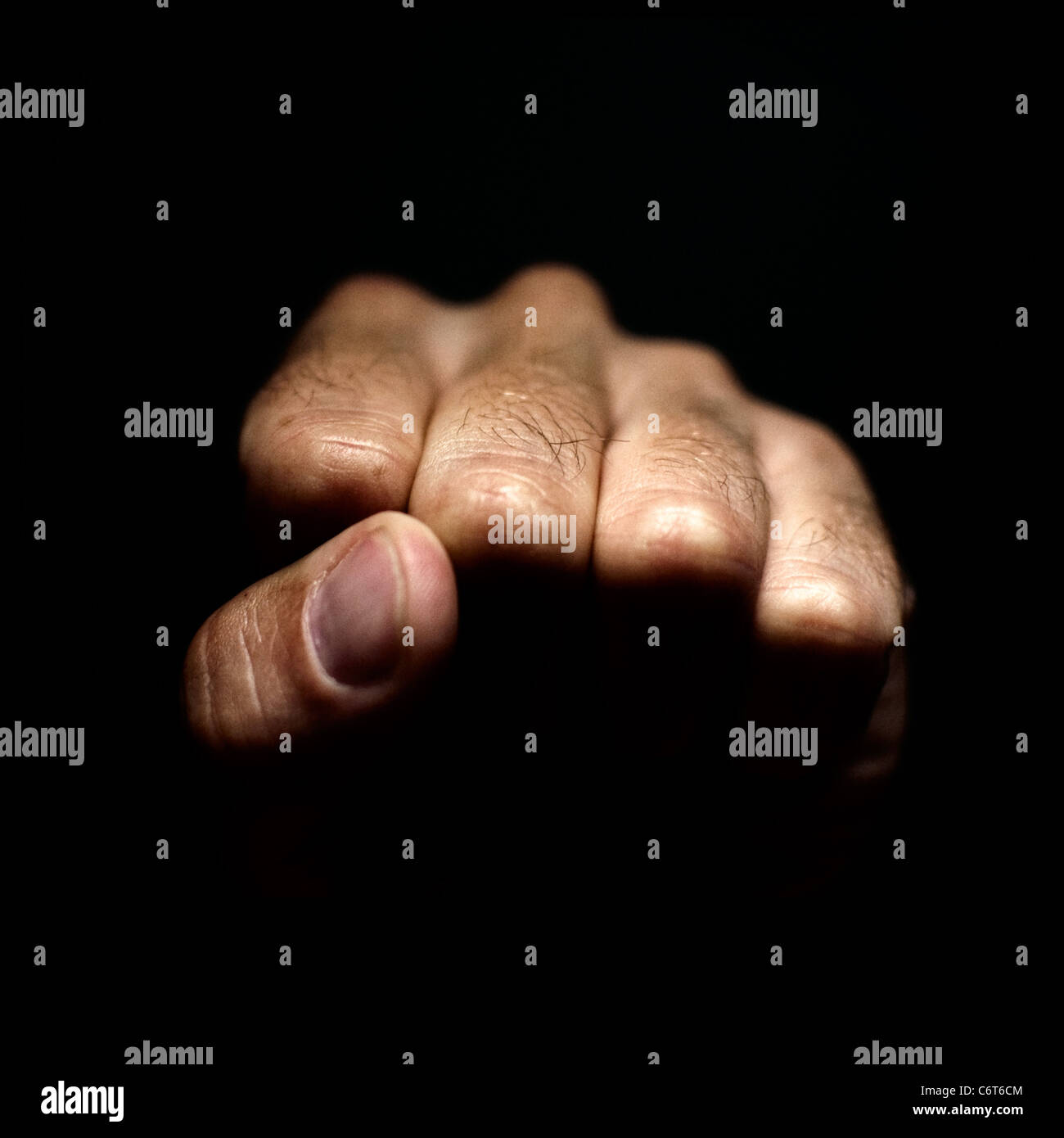 Male fist over a dark background, fight symbol and concept. Low key ...