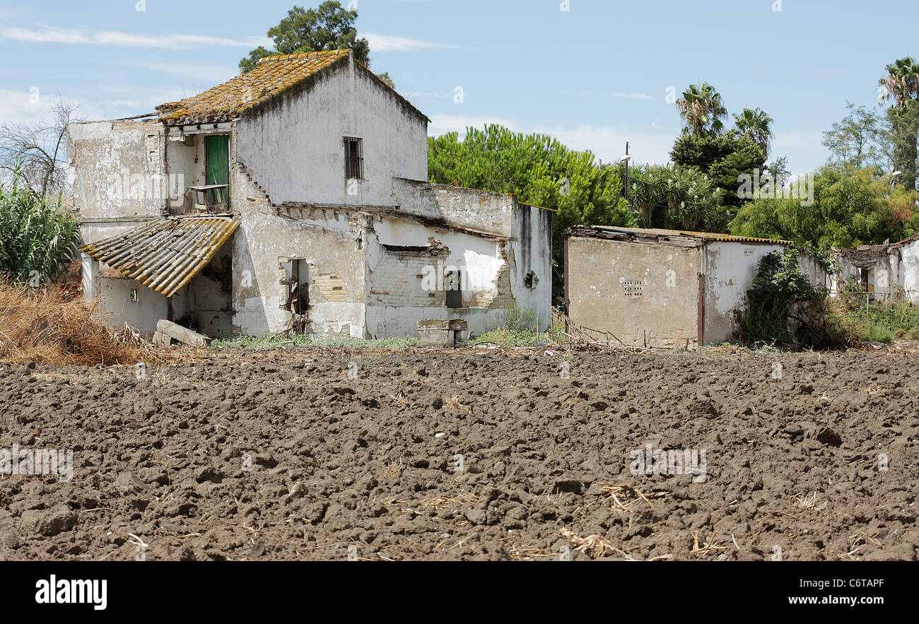 Rural two-story house in ruins at the foot of a field without sowing ...