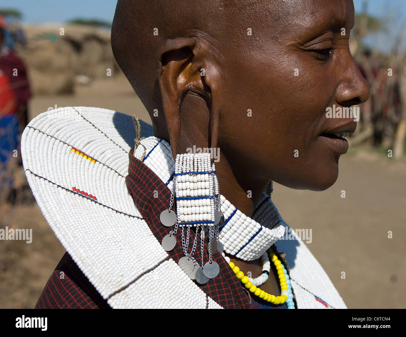 The traditional shaved head and the split ears and ornate bead earrings ...