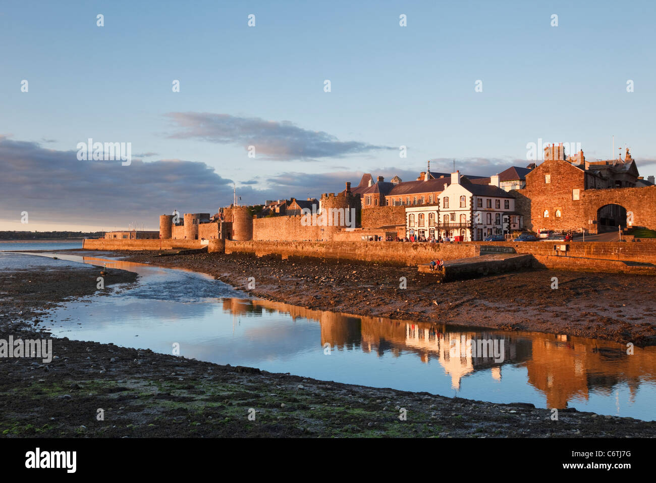 The Anglesey pub and town walls lit by evening sunlight reflected in ...