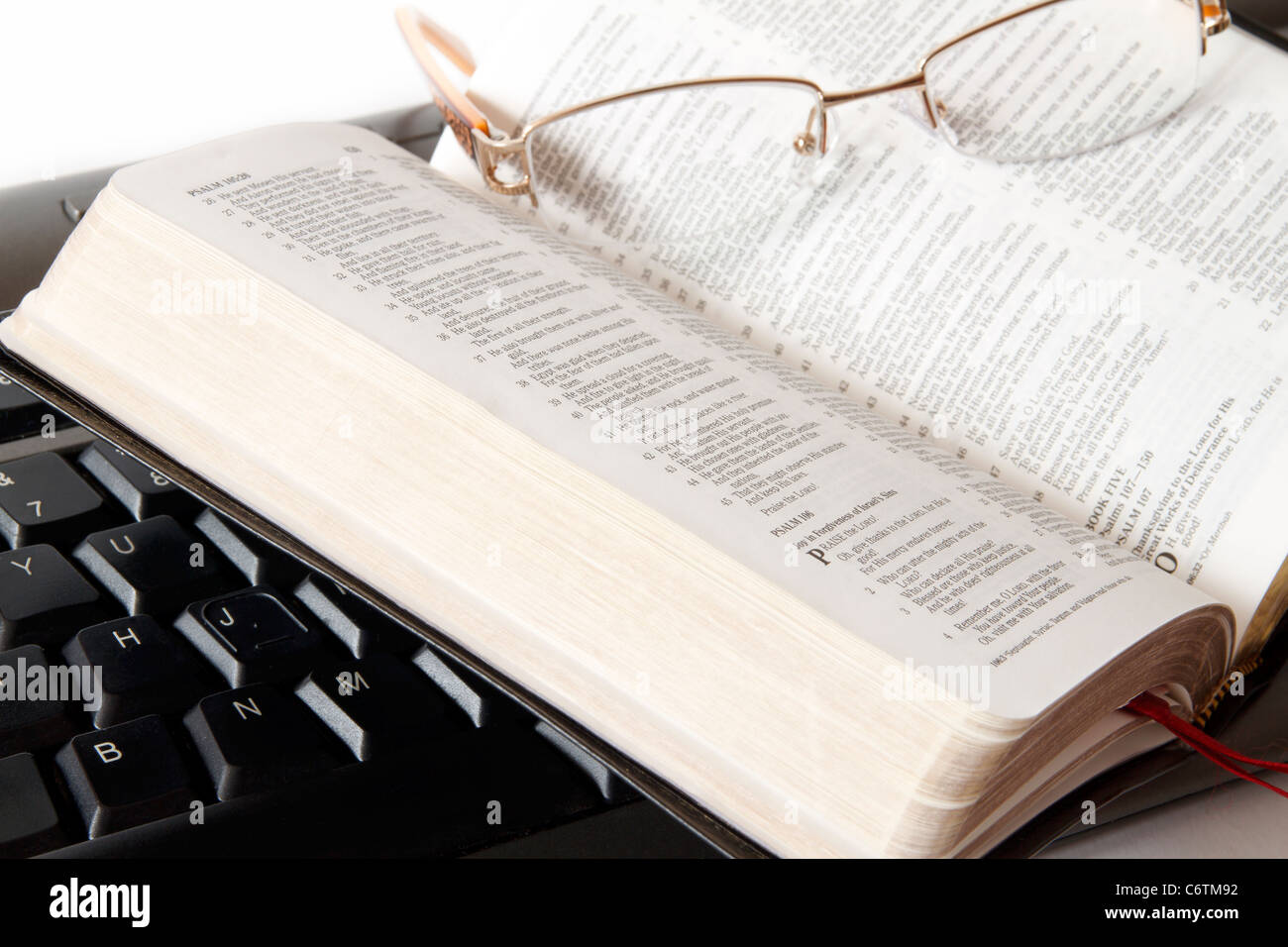 Holy Bible opened with glasses on a keyboard Stock Photo - Alamy