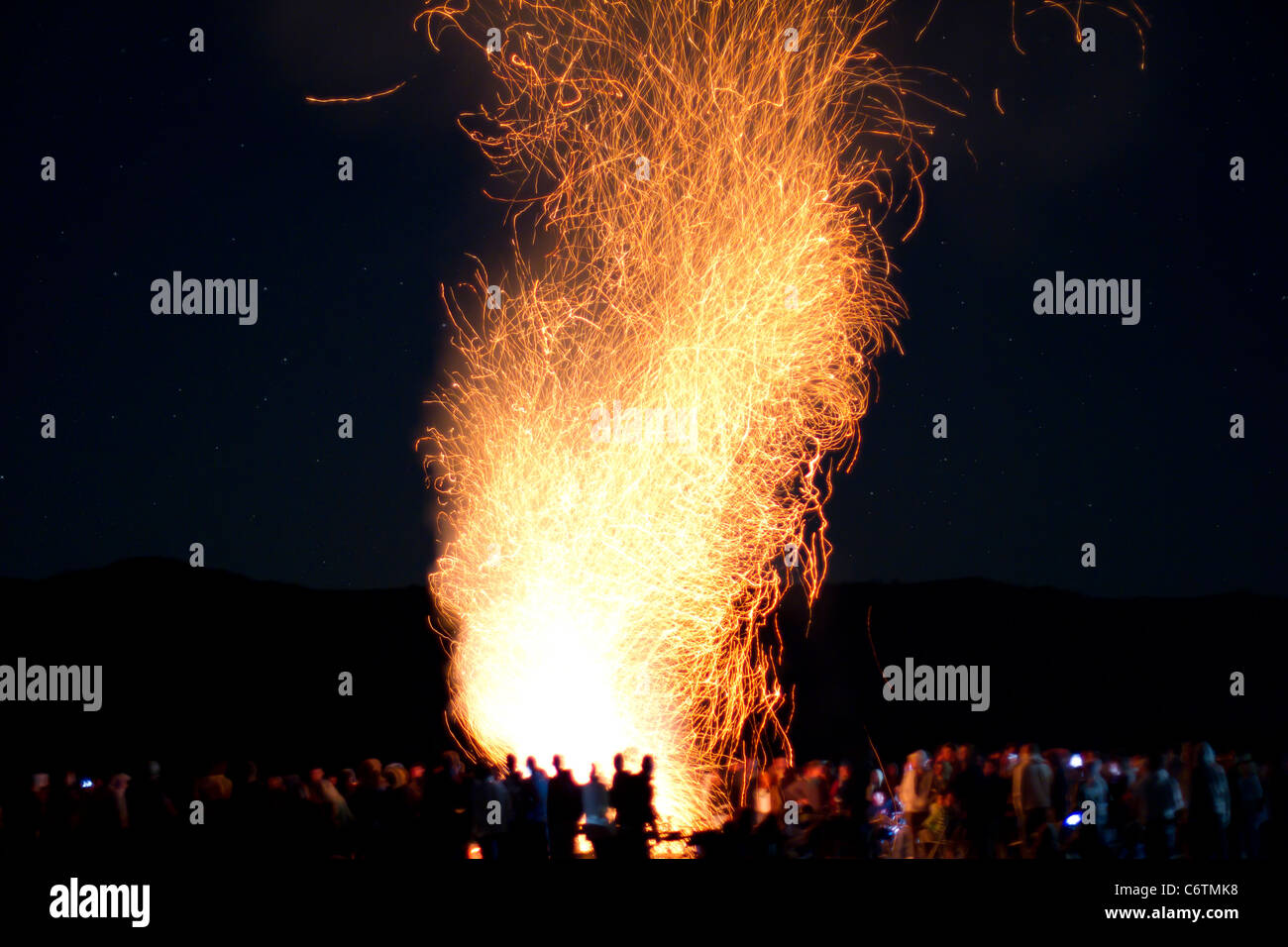 Big outdoor fire (campfire) with people silhouette, yellow red smoke ...