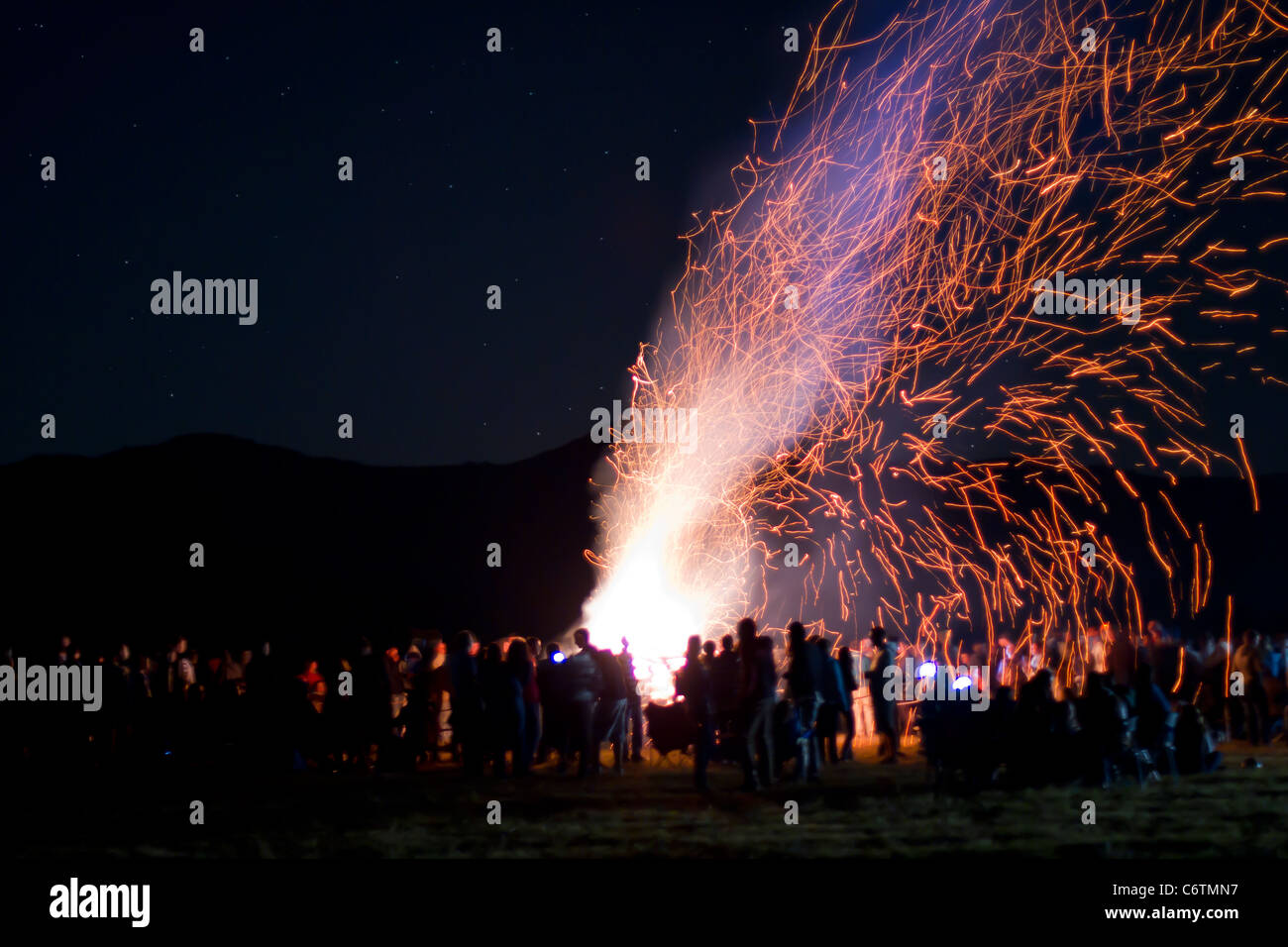 Big outdoor fire (campfire) with people silhouette, yellow red smoke ...