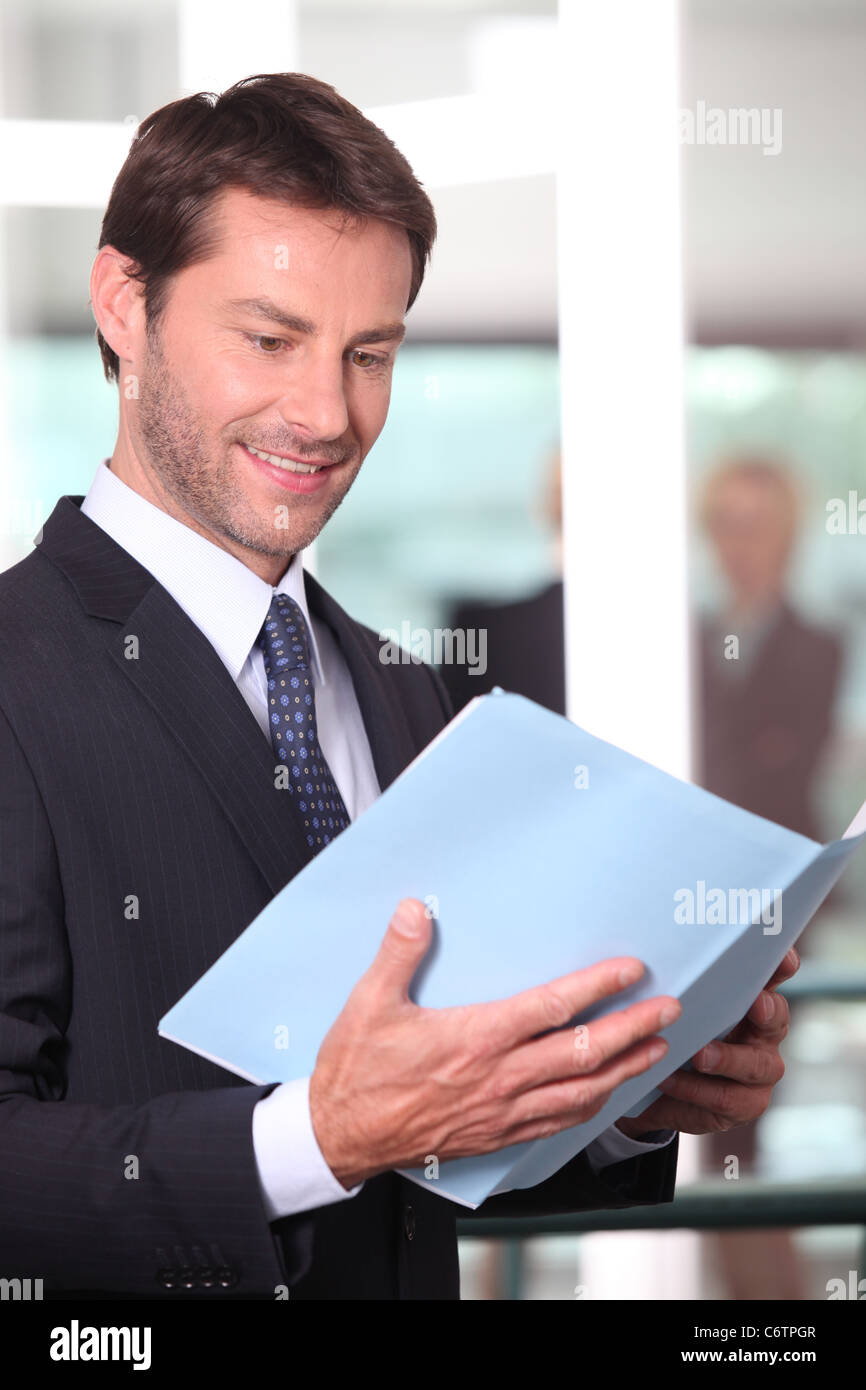 Happy executive reading a report Stock Photo - Alamy
