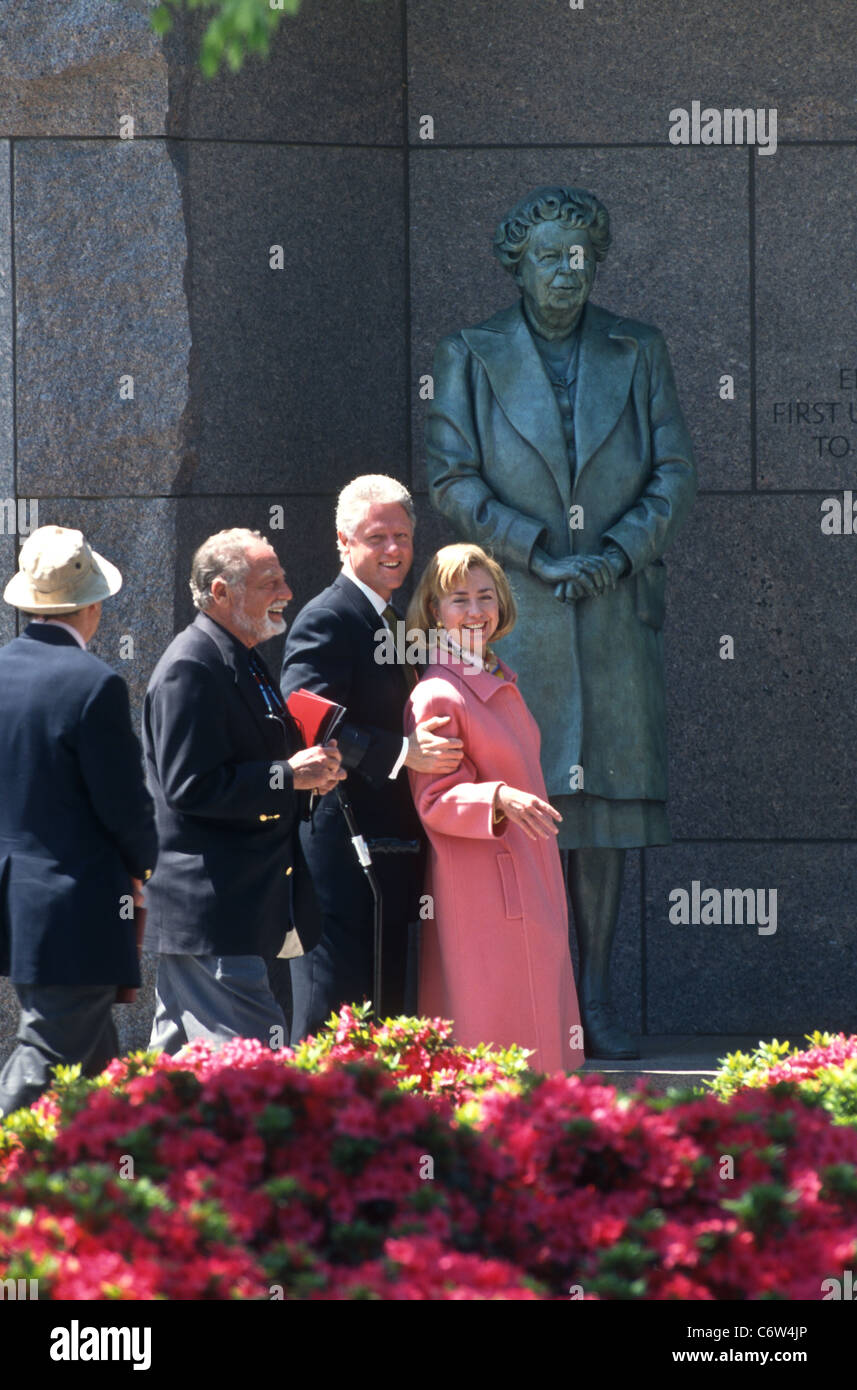 President Bill Clinton and First Lady Hillary walk past a statue of ...