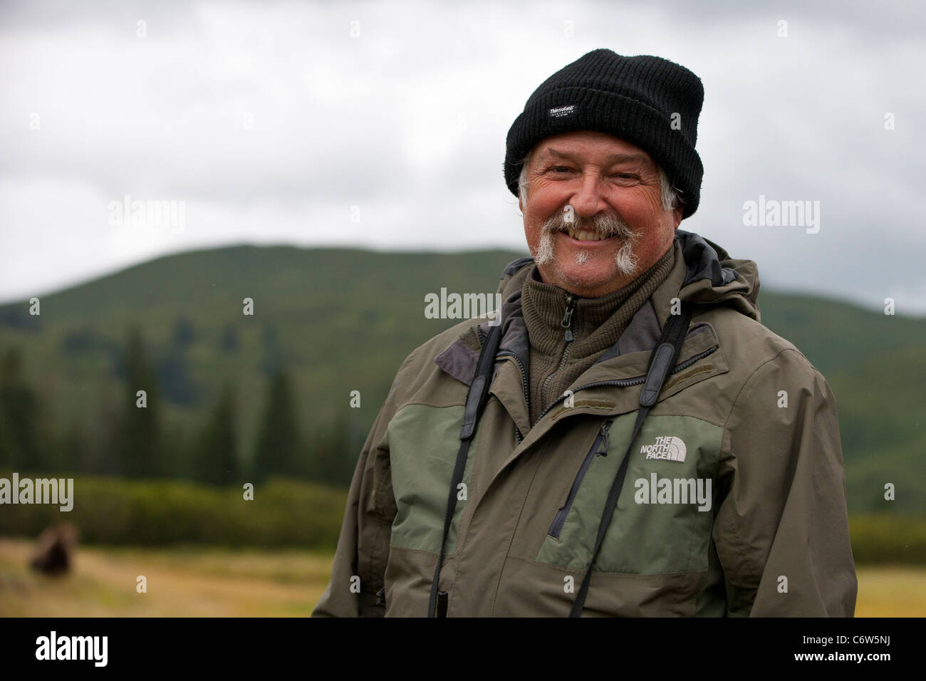 A tour guide scouts a field for North American brown bear, Lake Clark ...